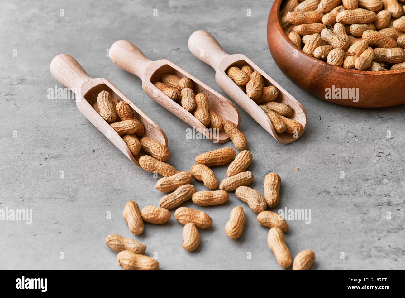 Image of wooden spoons with peanuts on a concrete surface Stock Photo ...