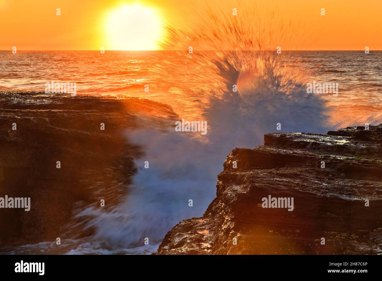 Splash of rolling wave hitting sandstone rocks on Narrabeen beach of ...