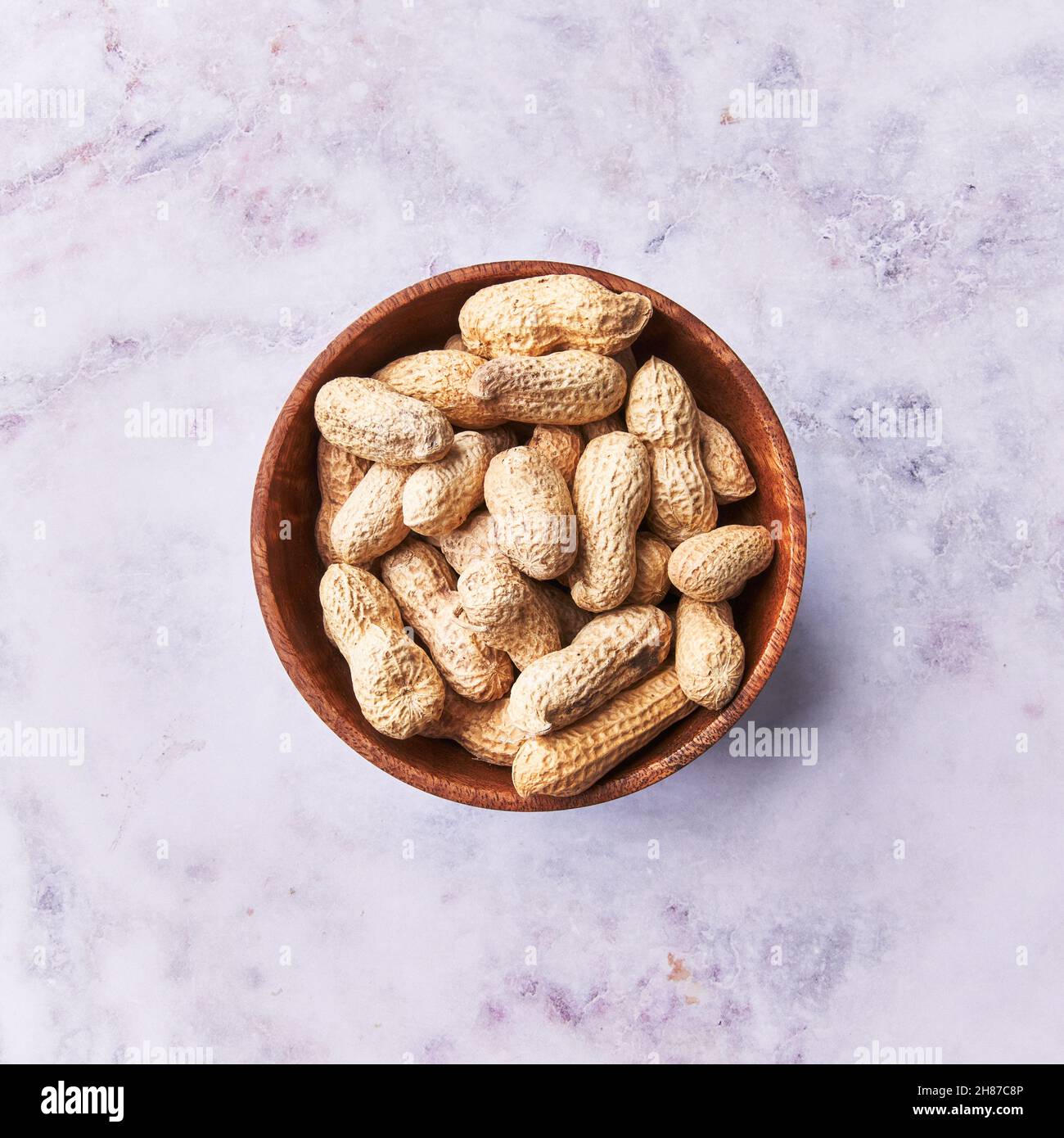 Bowl of peanuts with shell on a marble surface Stock Photo - Alamy