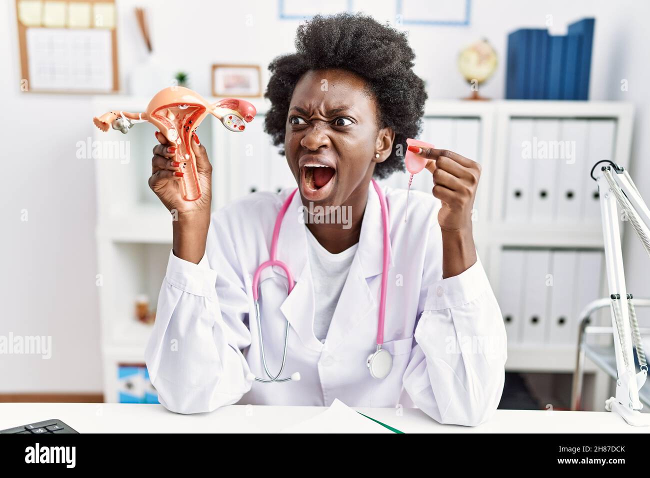 African doctor woman holding anatomical female genital organ and ...