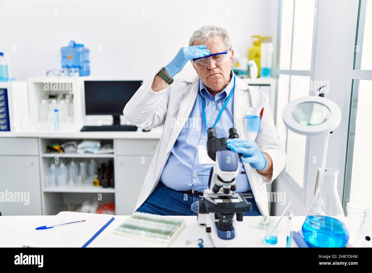 Senior caucasian man working at scientist laboratory worried and ...