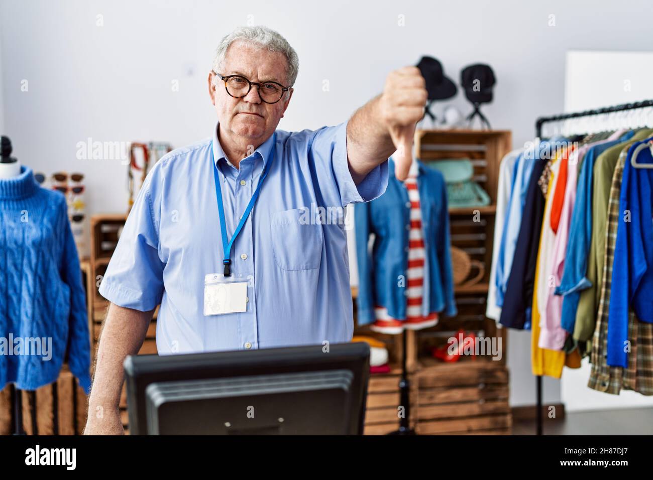 Senior man with grey hair working as manager at retail boutique looking ...