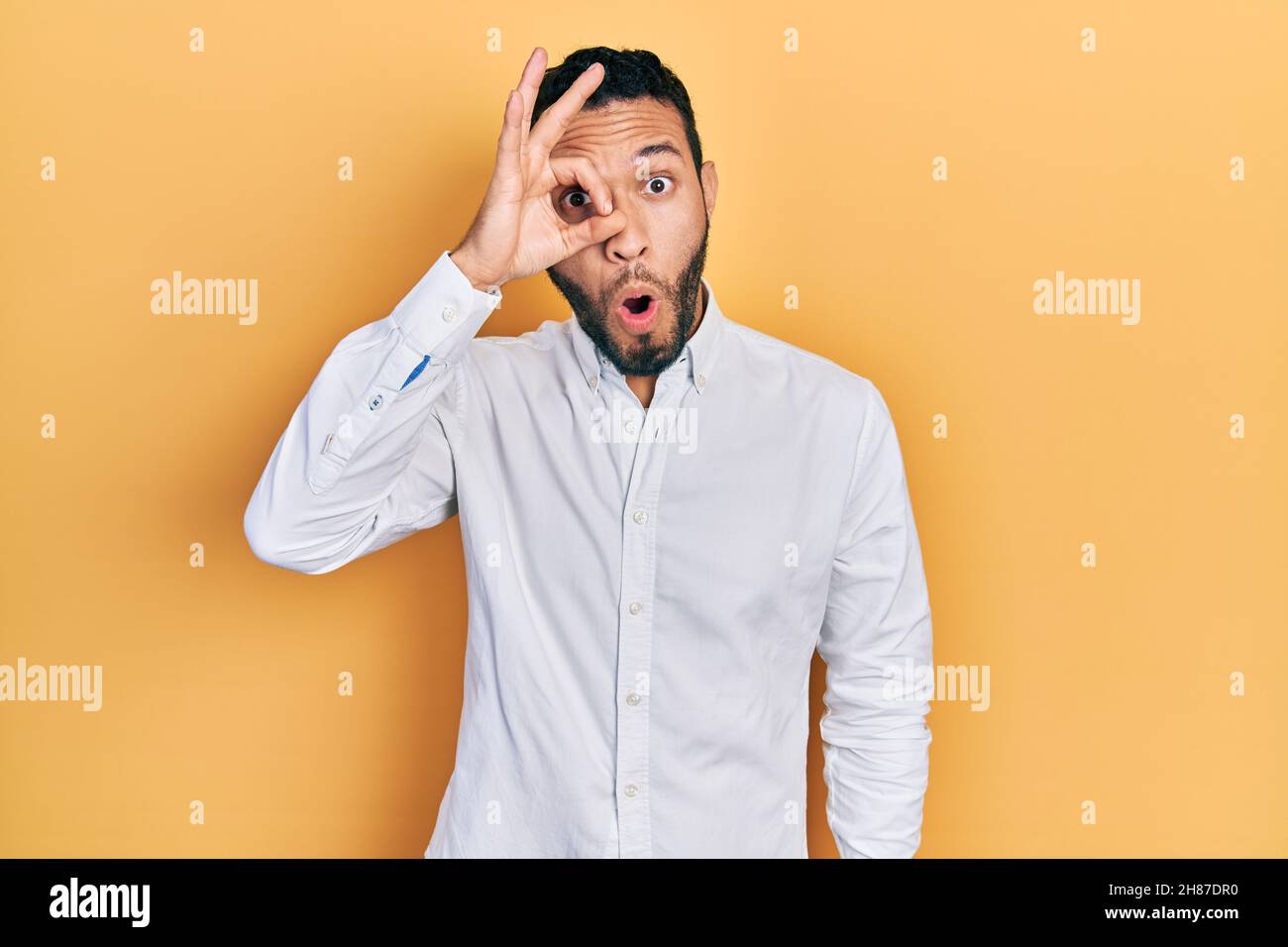 Hispanic man with beard wearing business shirt doing ok gesture shocked ...