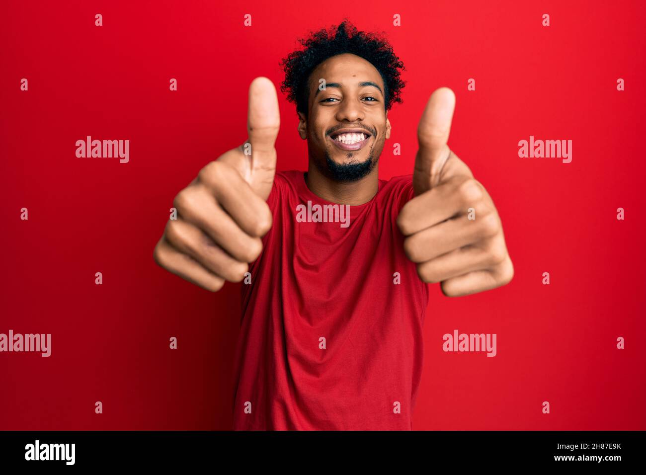 Young african american man with beard wearing casual red t shirt ...