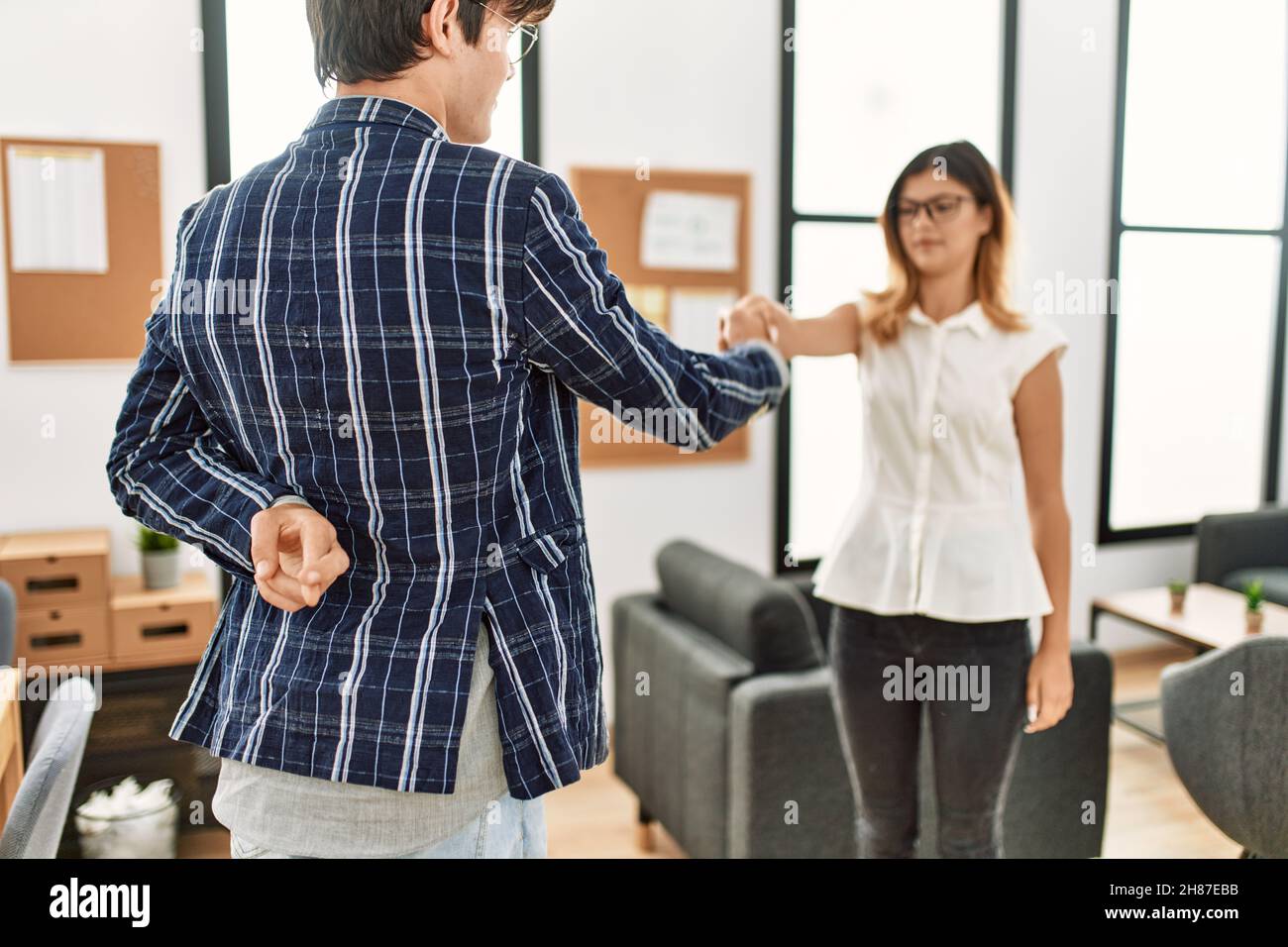 Two business workers smiling happy shaking hands. Man standing with ...