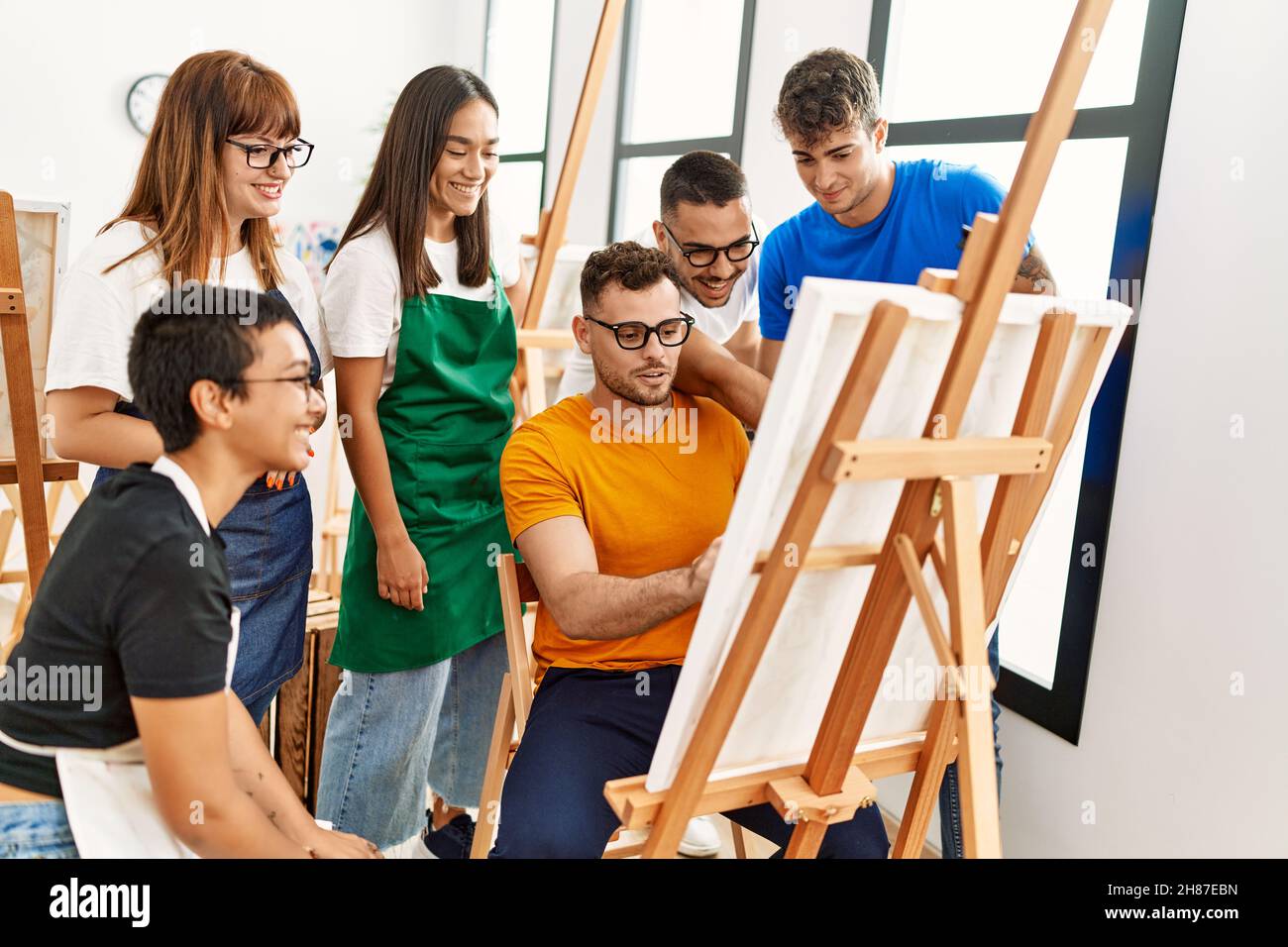 Group of people smiling happy and looking draw of partner at art studio ...