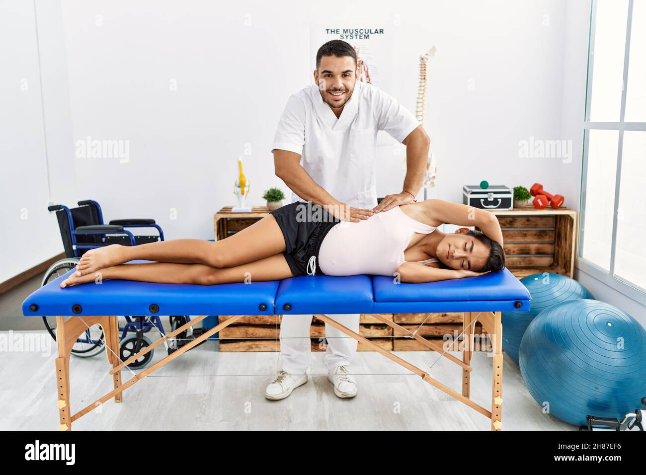 Latin man and woman wearing physiotherapist uniform having pregnancy ...