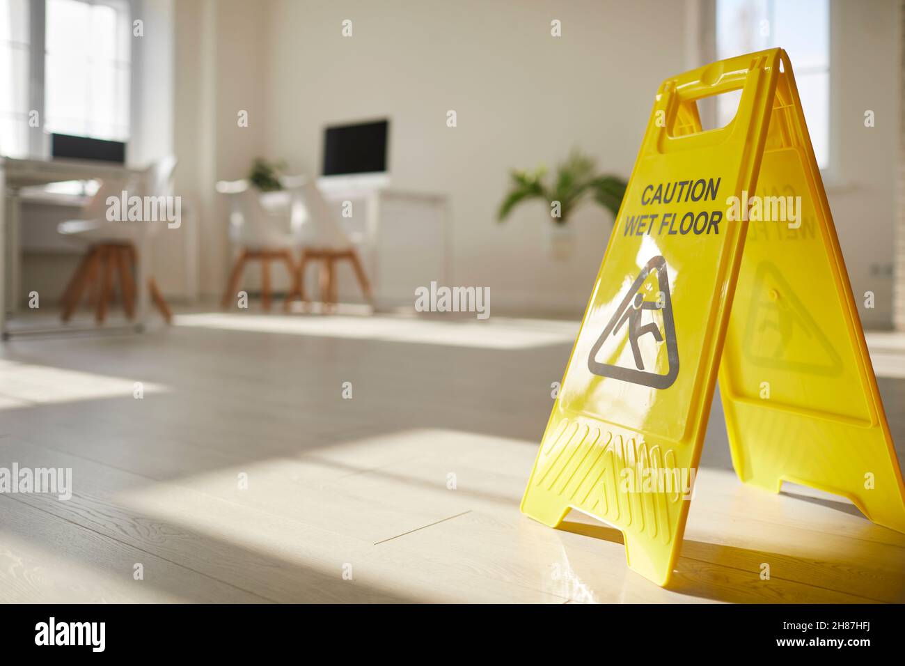 Yellow caution sign of wet floor on surface Stock Photo - Alamy