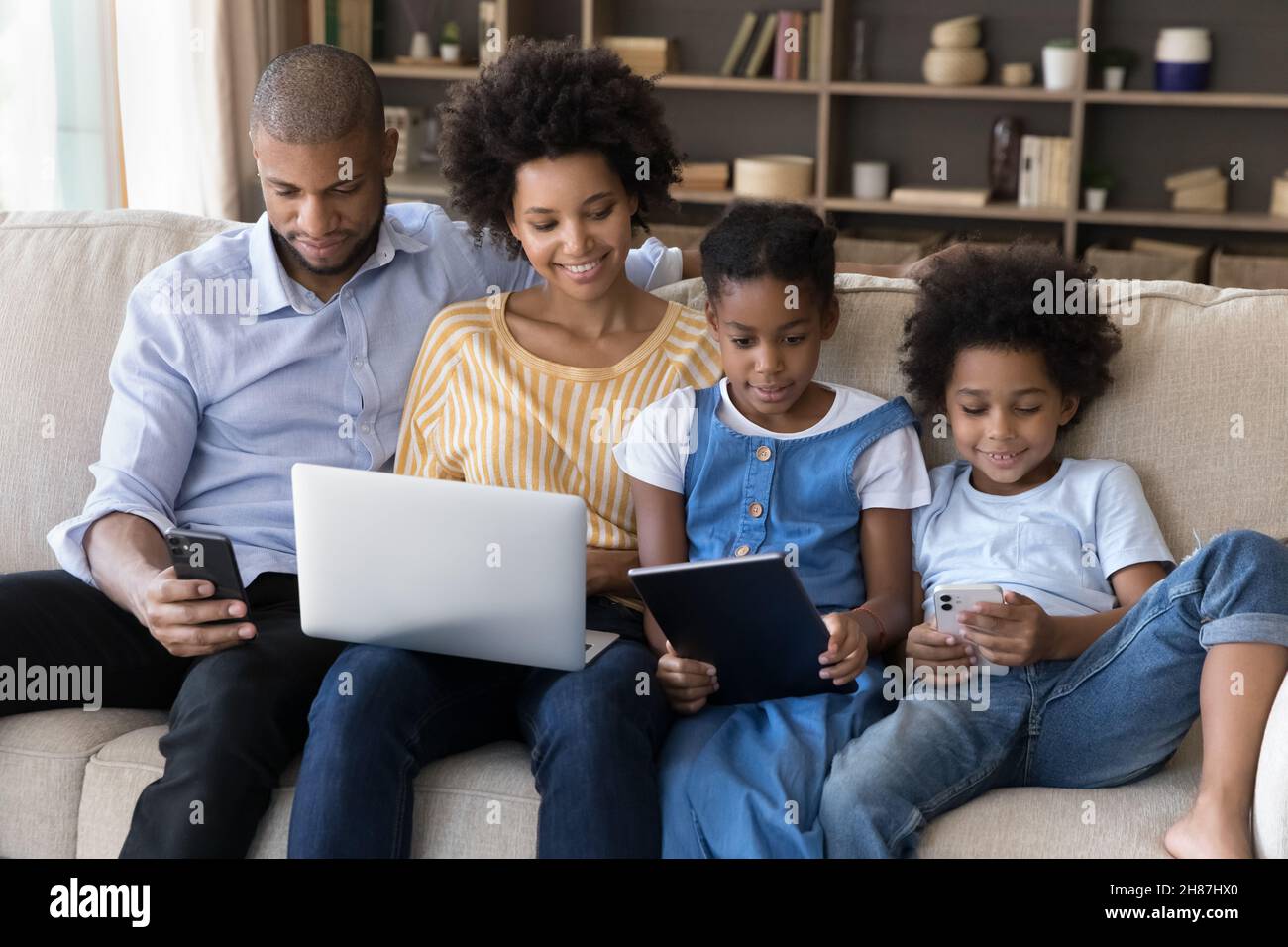 African American family engaged in digital gadgets using Stock Photo ...
