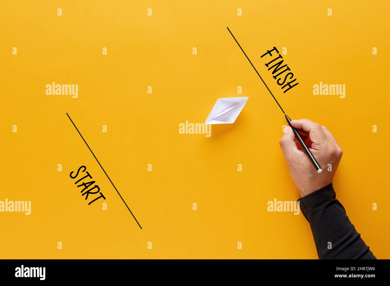 Paper boat floats from the start line to the finish line drawn by a ...