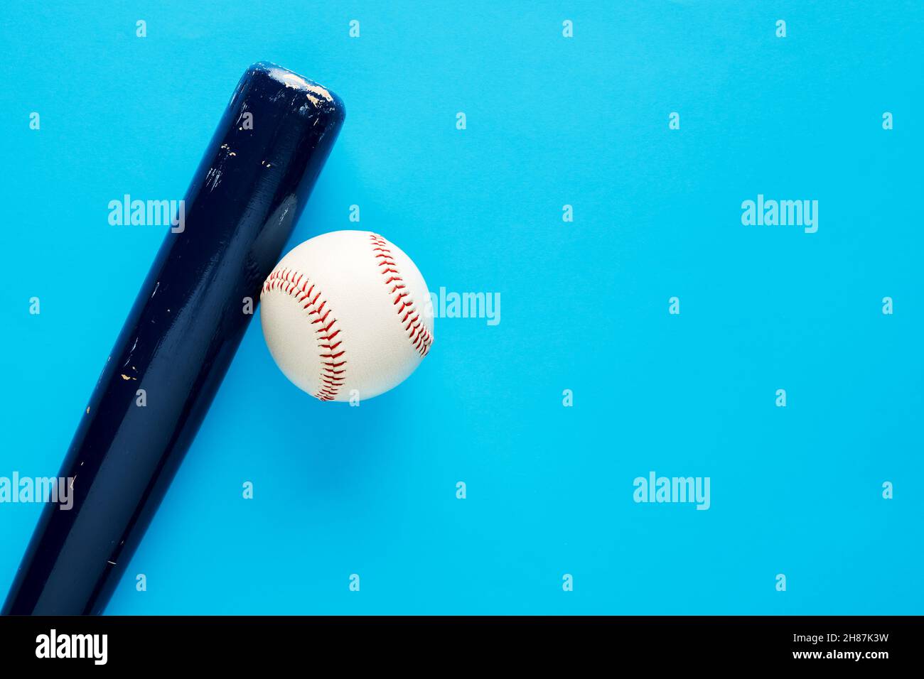 Wooden baseball bat and a baseball ball on blue background with copy ...