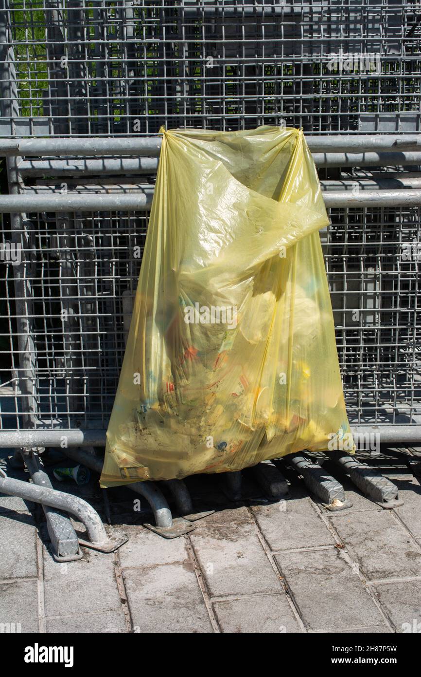 A plastic trash bag on a metallic grid fence on the street Stock Photo ...