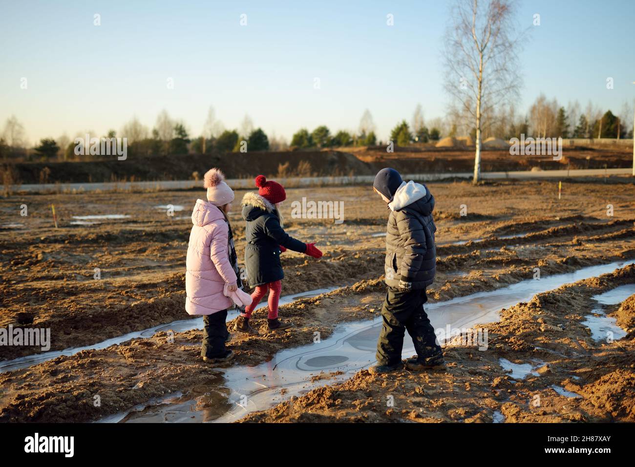 Group of children playing with thin ice puddles formed on the frozen ...
