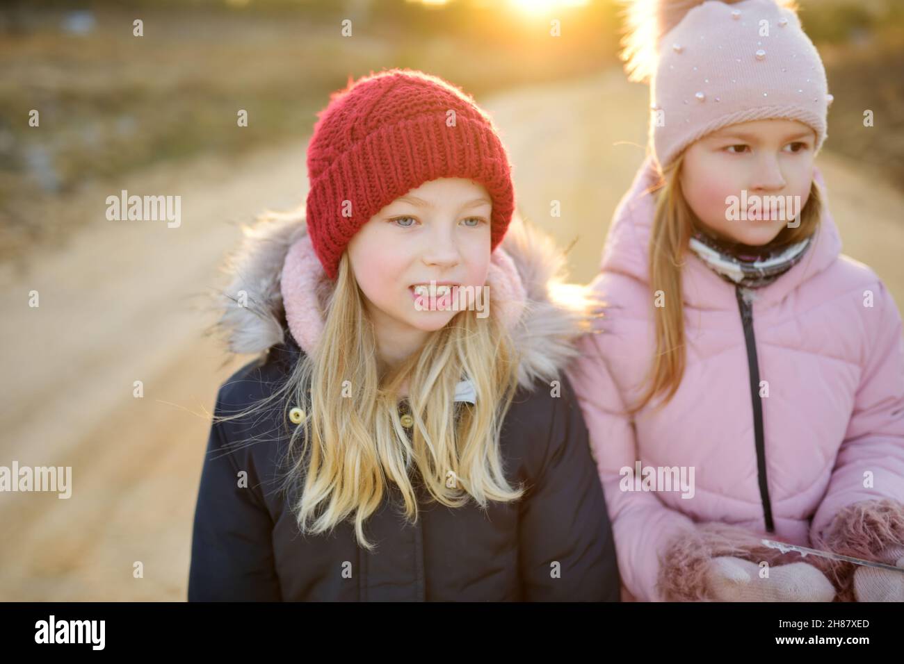 Two cute young sisters having fun during forest hike on beautiful early ...
