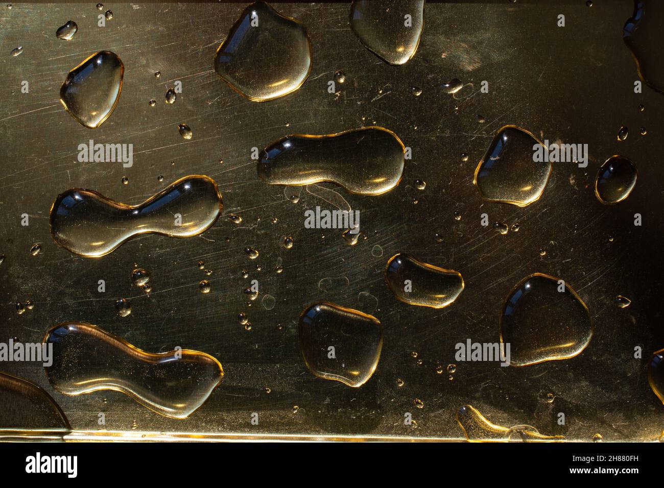 A macro shot of water droplets on a gray surface in dim lighting Stock ...