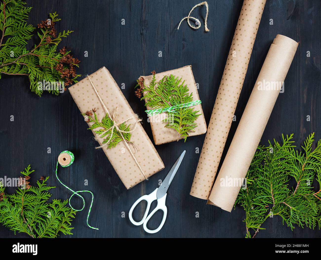 Wrapping Christmas gift boxes in craft paper Stock Photo - Alamy
