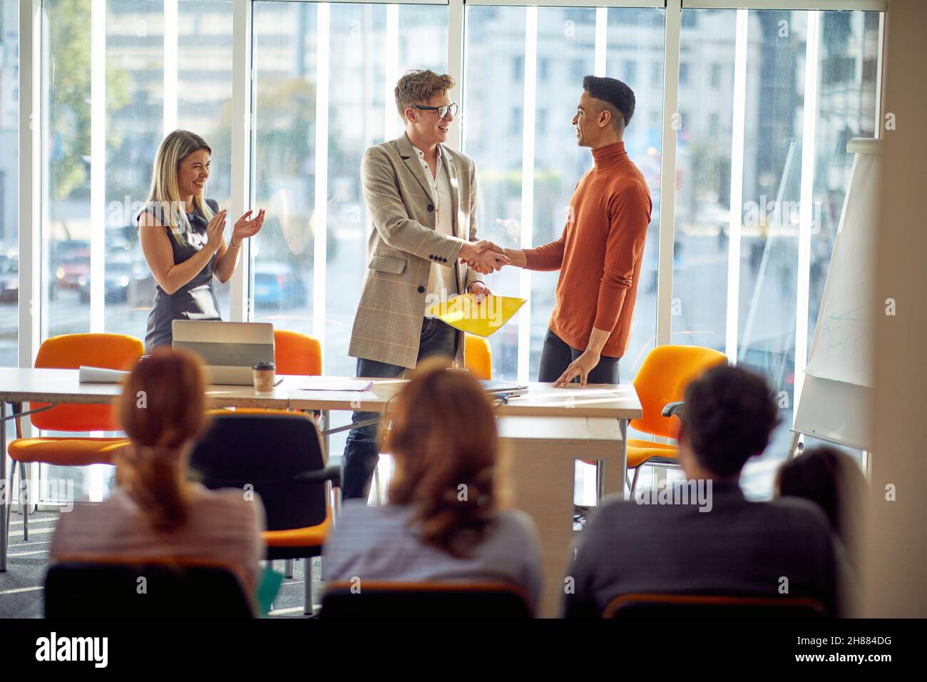 young business man is receiving congratulations from a employees Stock ...