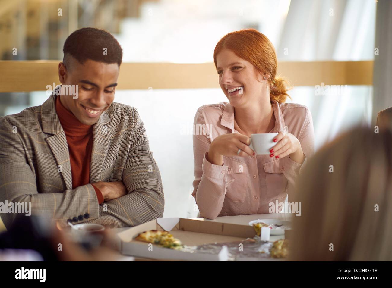 Young business colleagues chatting in a friendly atmosphere after lunch ...