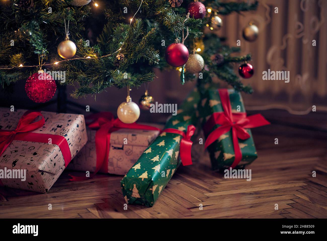 Beautiful Christmas gift boxes on floor near fir tree in room Stock ...