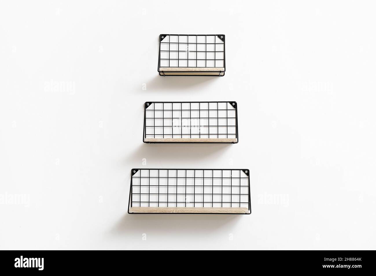 Modern empty shelves hanging on light wall Stock Photo - Alamy