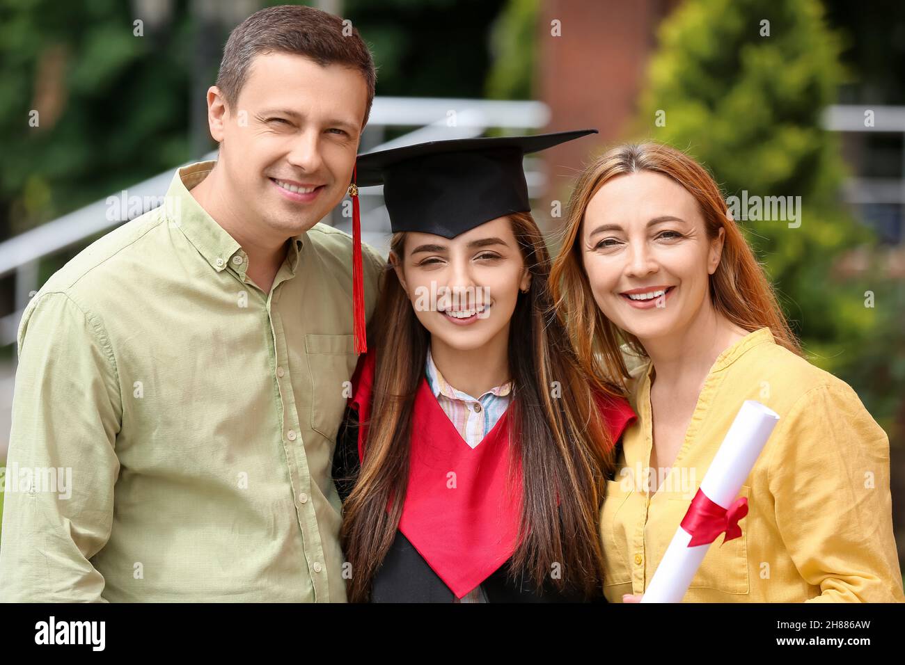 Happy young woman with her parents on graduation day Stock Photo - Alamy