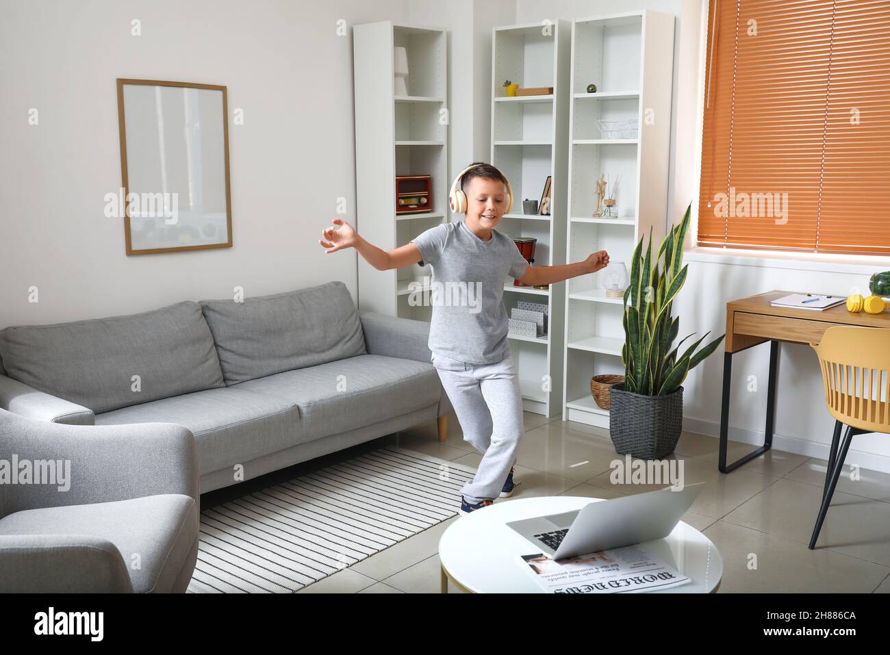 Funny little boy with laptop learning to dance at home Stock Photo - Alamy