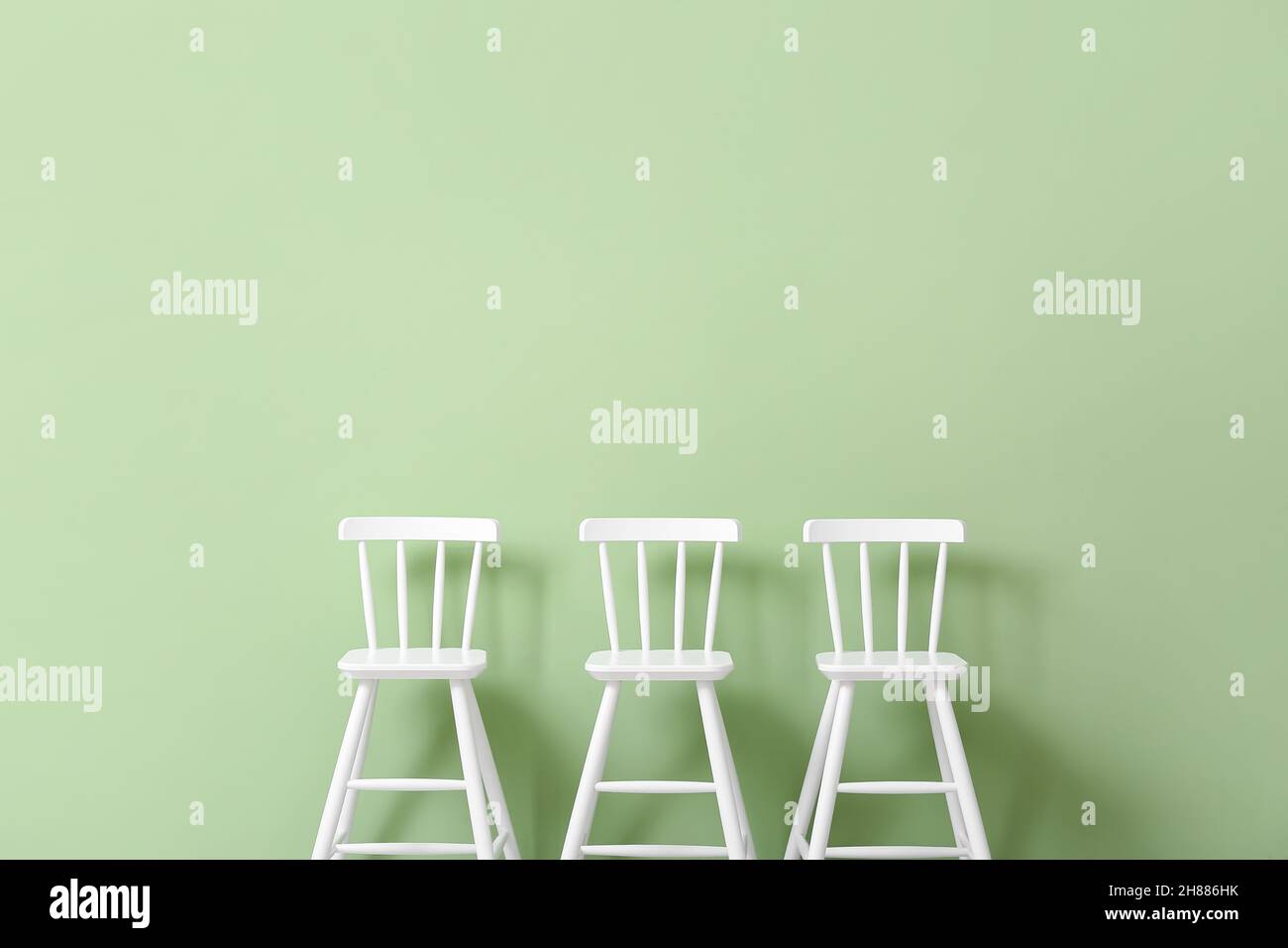 White chairs for children on green background Stock Photo - Alamy