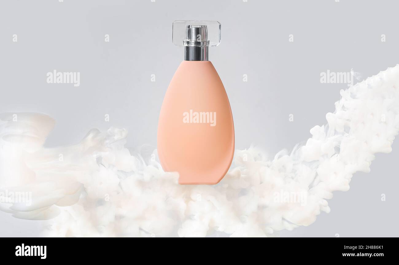 Perfume bottle in light smoke on grey background Stock Photo - Alamy
