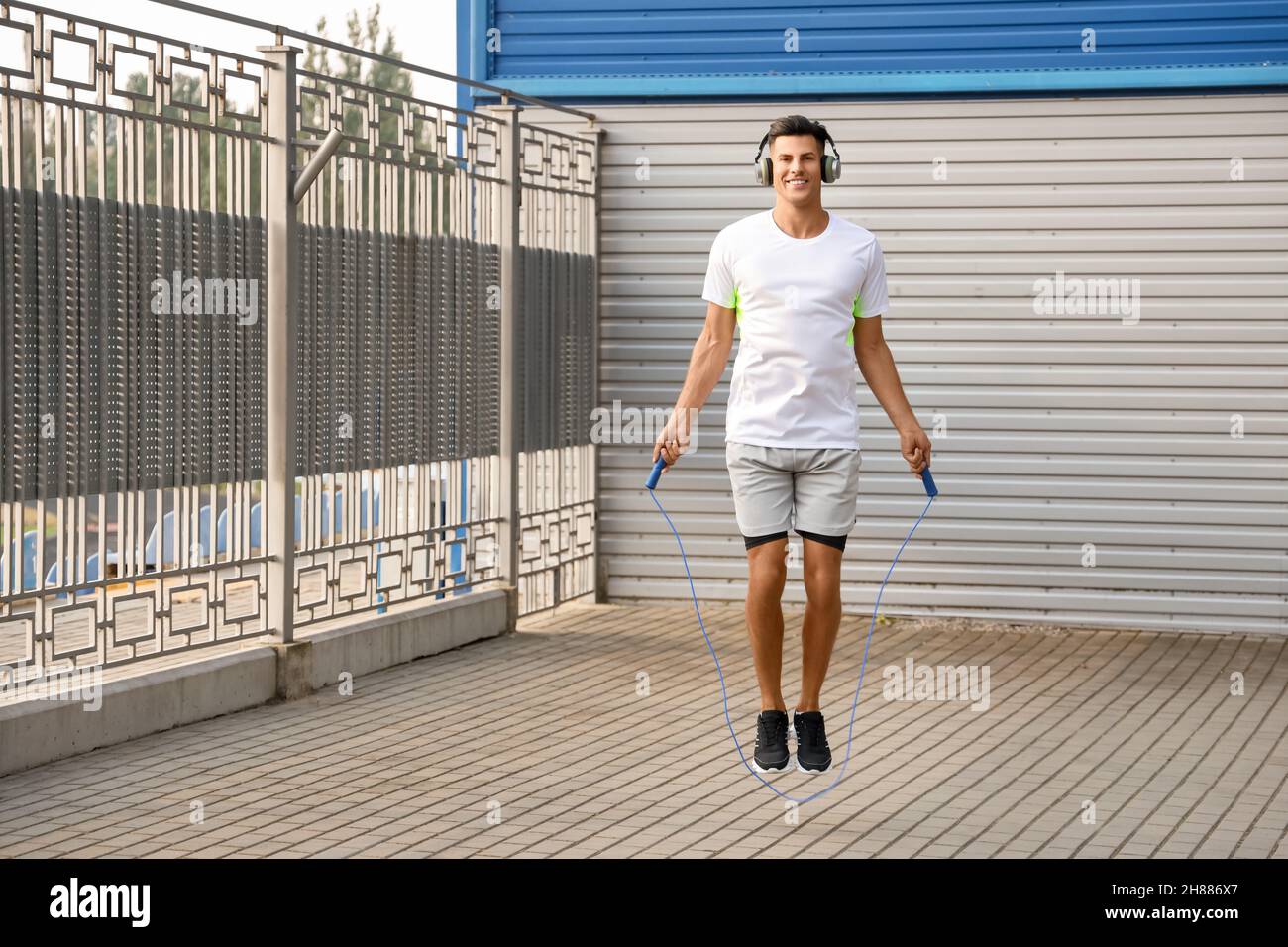 Sporty young man jumping rope outdoors Stock Photo - Alamy
