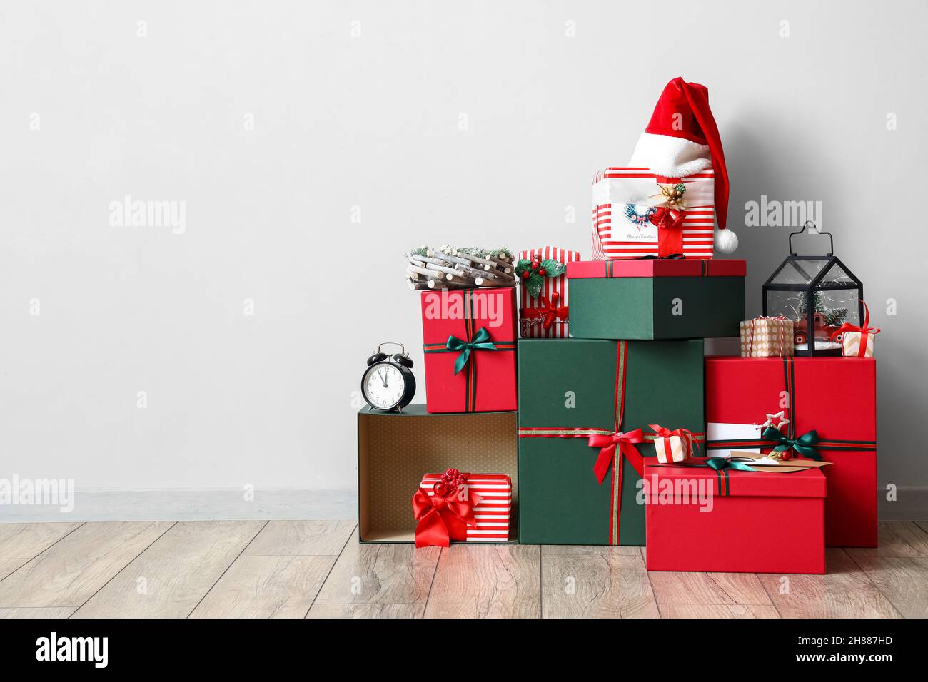 Different Christmas gift boxes, decor and alarm clock on floor near ...