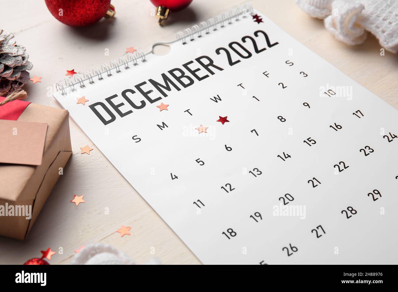 Paper calendar for December 2022, Christmas decor and confetti on light ...