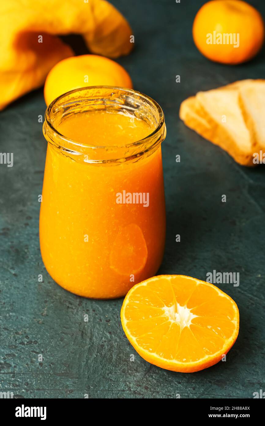 Jar of tasty tangerine jam on dark background Stock Photo - Alamy