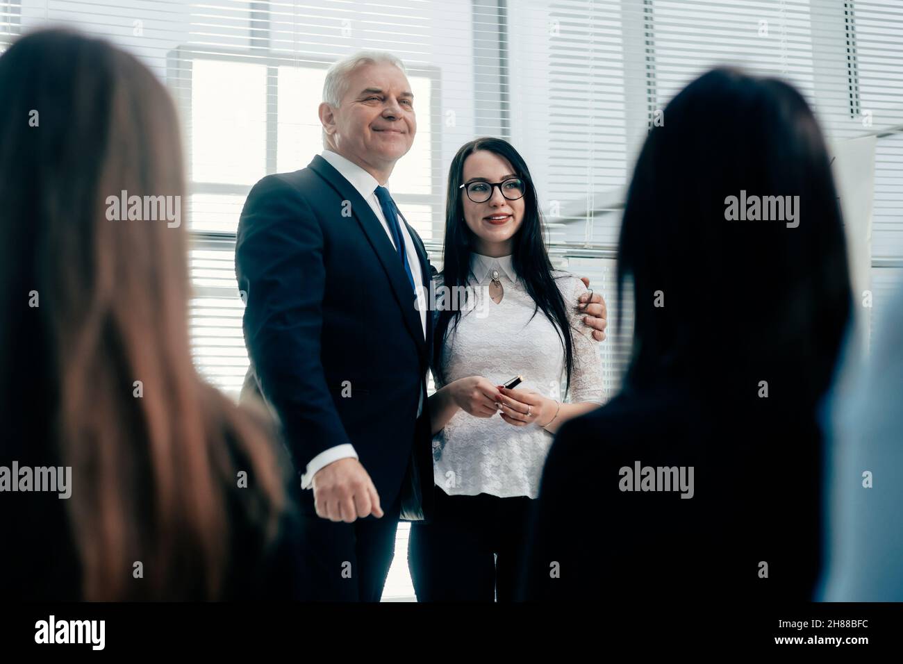 boss and young speaker standing together in front of business ...
