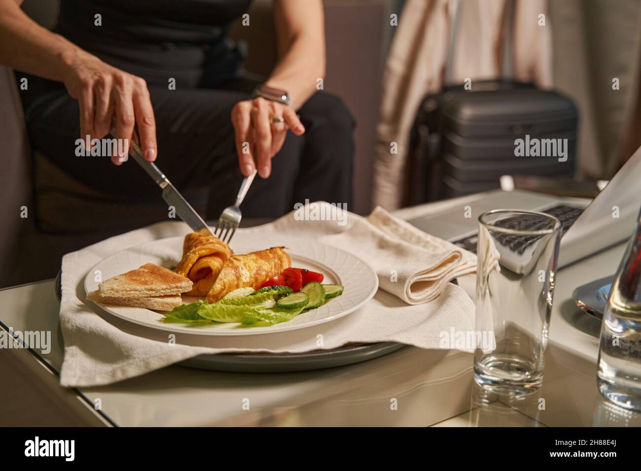 Female using fork and knife for eating her dinner Stock Photo - Alamy