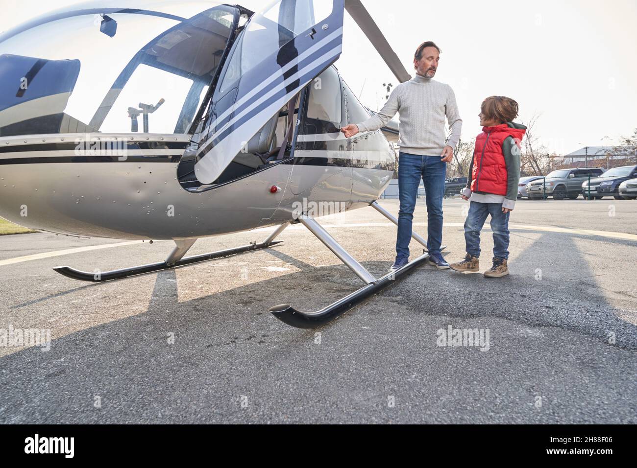 Loving father talking to his son near a helicopter Stock Photo - Alamy