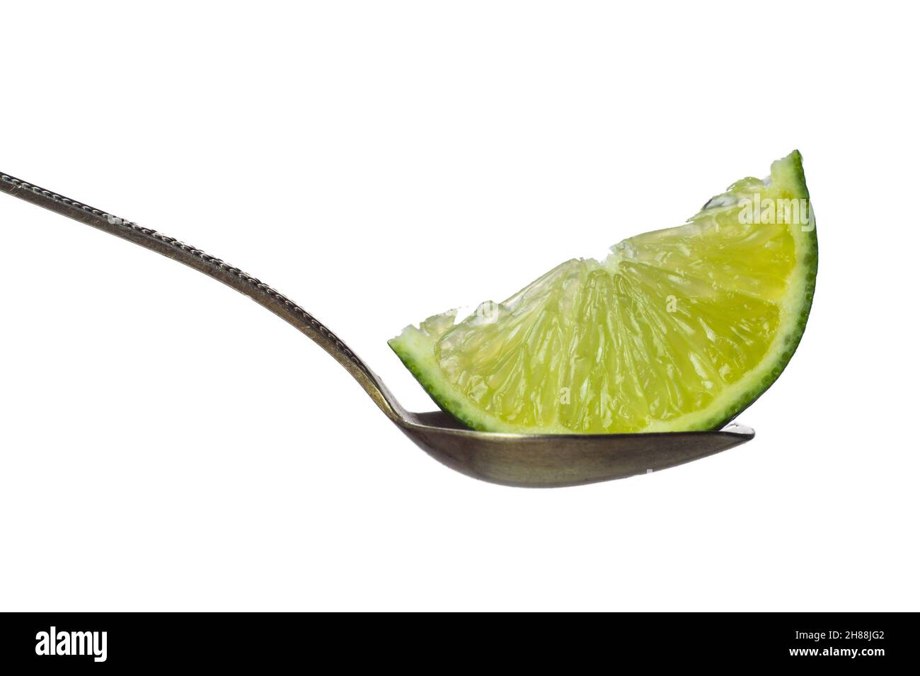 Slice of green lime in spoon isolated on white Stock Photo - Alamy