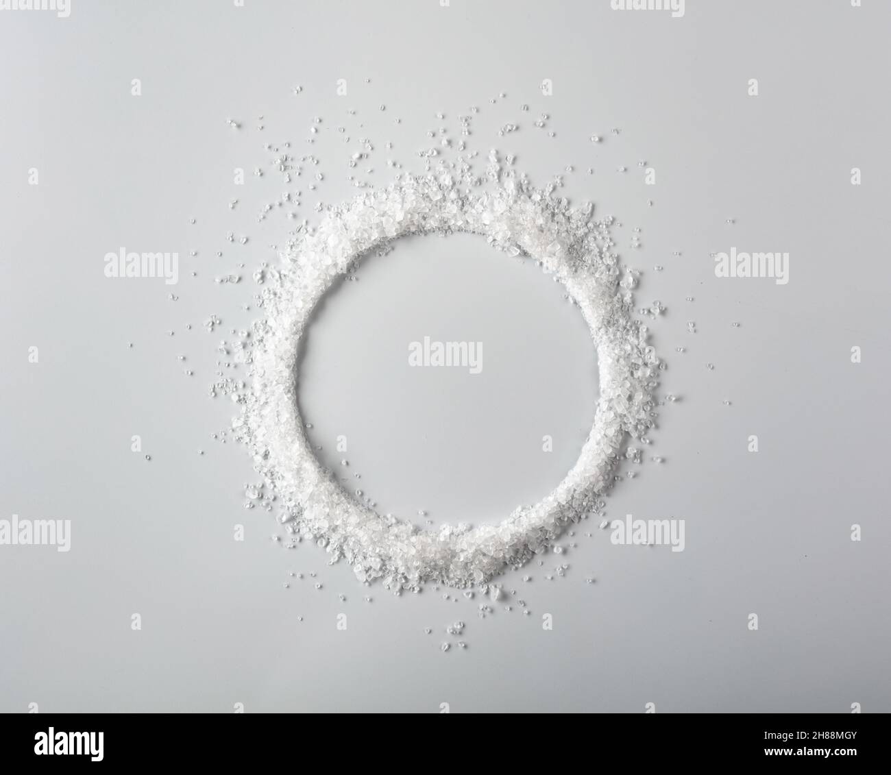 Salt is scattered on a white background. Round copy space. Top view ...