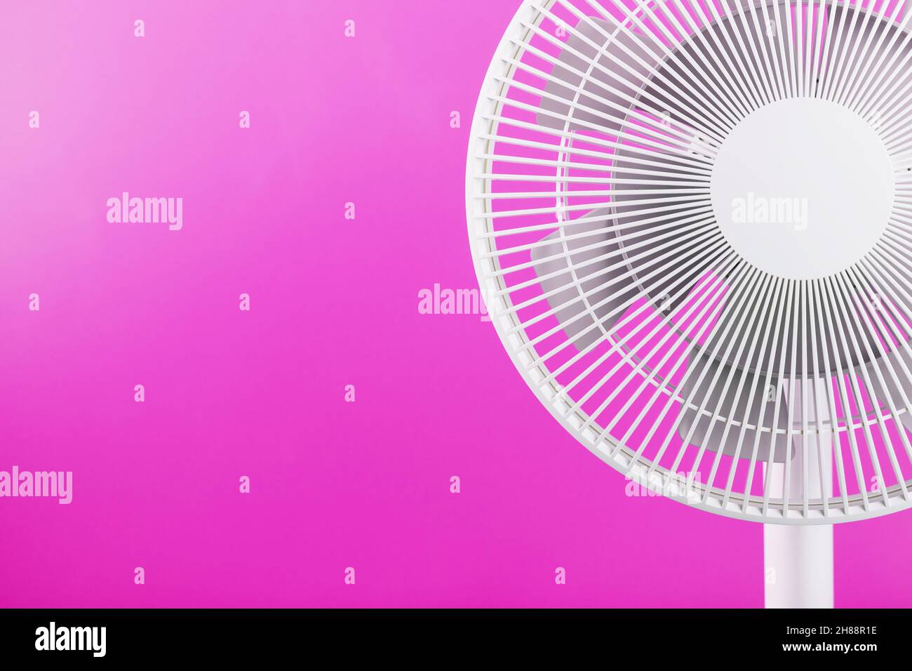 A high-tech white electric fan with a modern design for cooling the ...