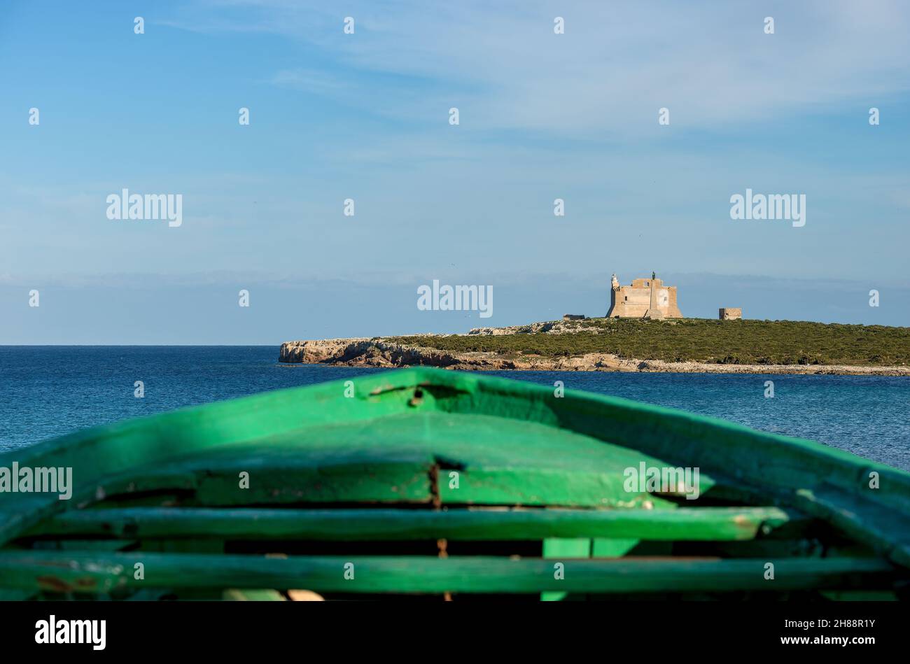 The Capo Passero Island (Cape Passero) with a boat of migrants ...