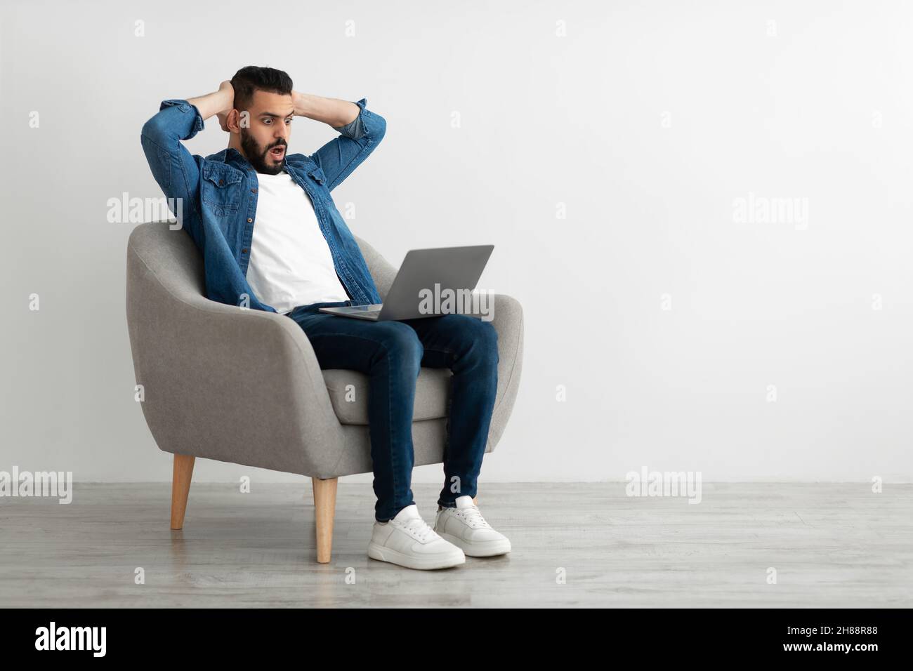 Terrified Arab freelancer looking at laptop screen, grabbing head ...