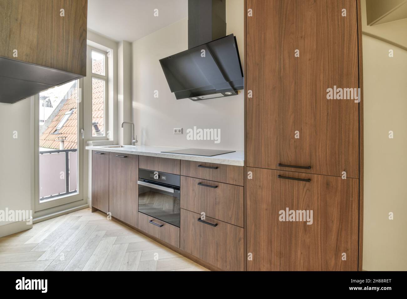 Classy kitchen with dark brown wooden kitchen unit and door leading to ...
