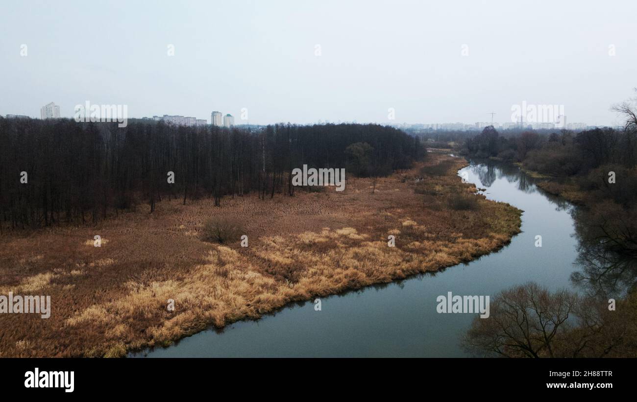 The river among the city park. Late autumn, cloudy. Trees without ...