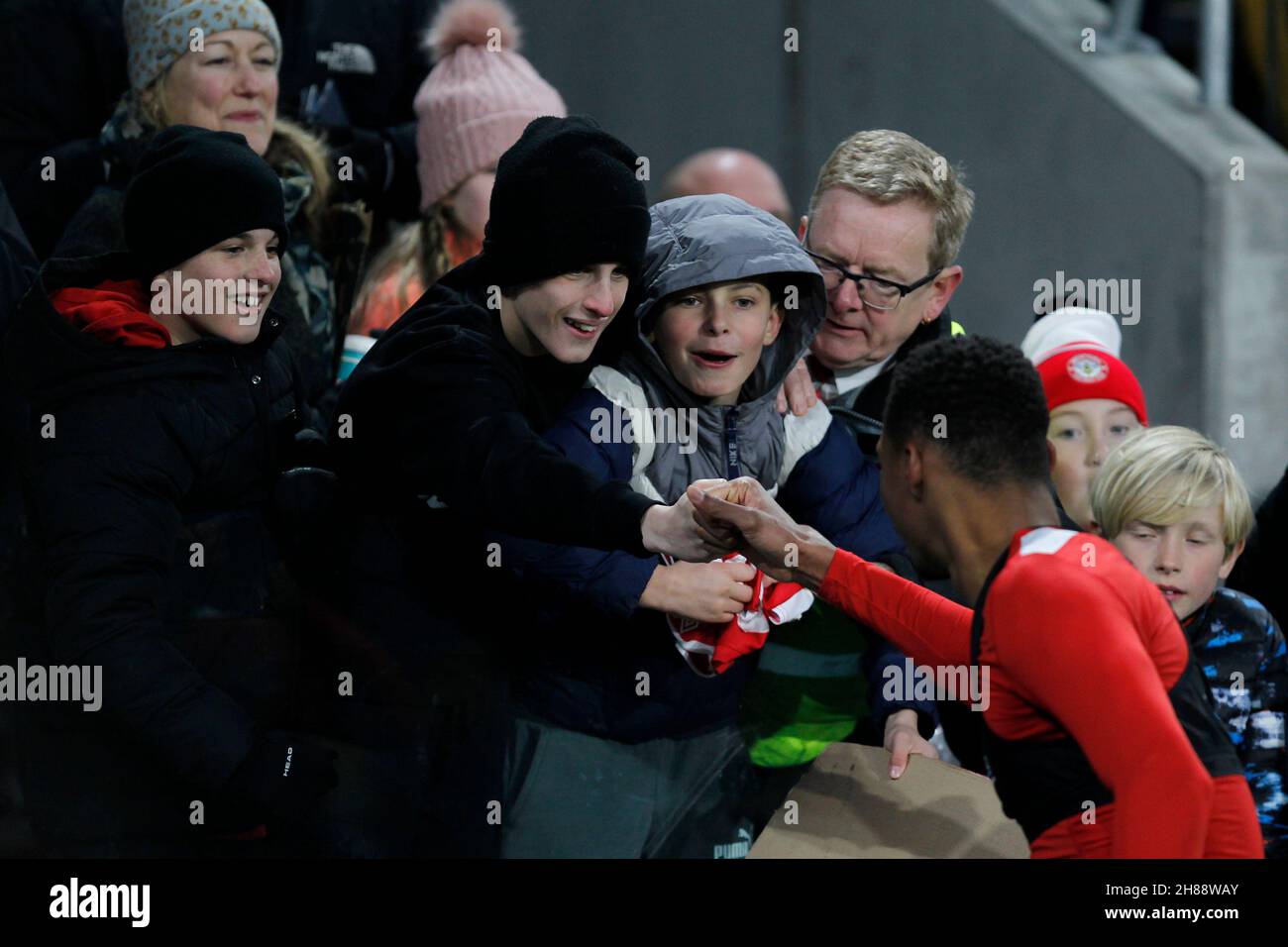 London, UK. 28th Nov, 2021. A young Brentford fan gets the shirt ofd ...