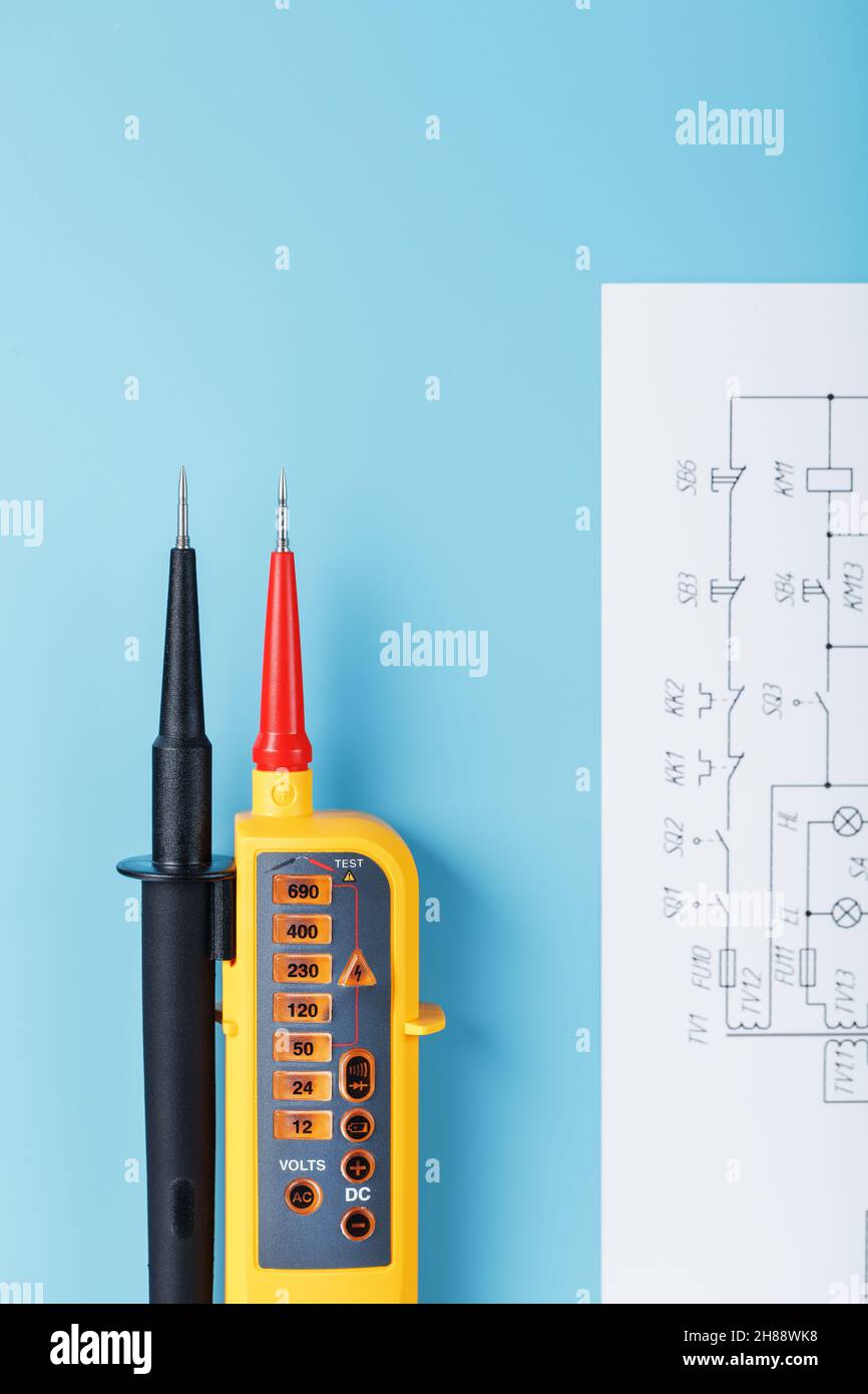 Two-pole voltage indicator with electrical drawings on a blue ...
