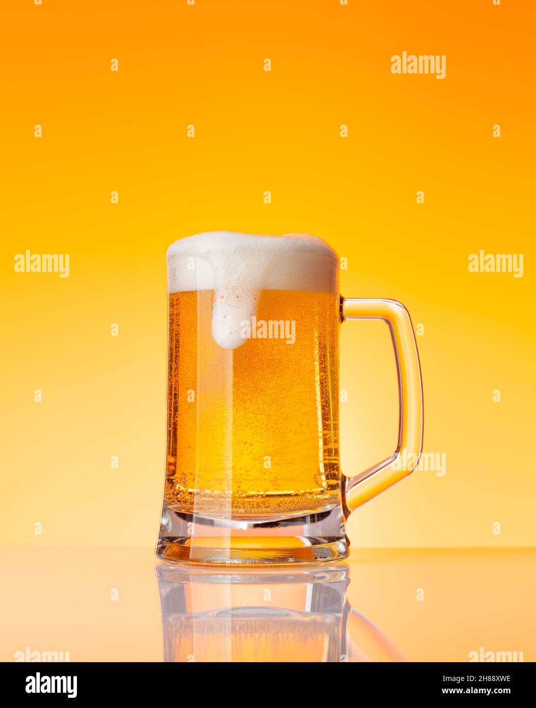 Glass with lager beer in front of yellow background. Studio shot Stock ...