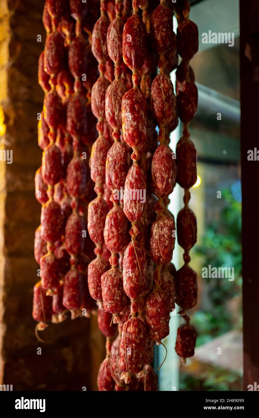 Variety of homemade dried salami sausages hanging in butchery shop in ...