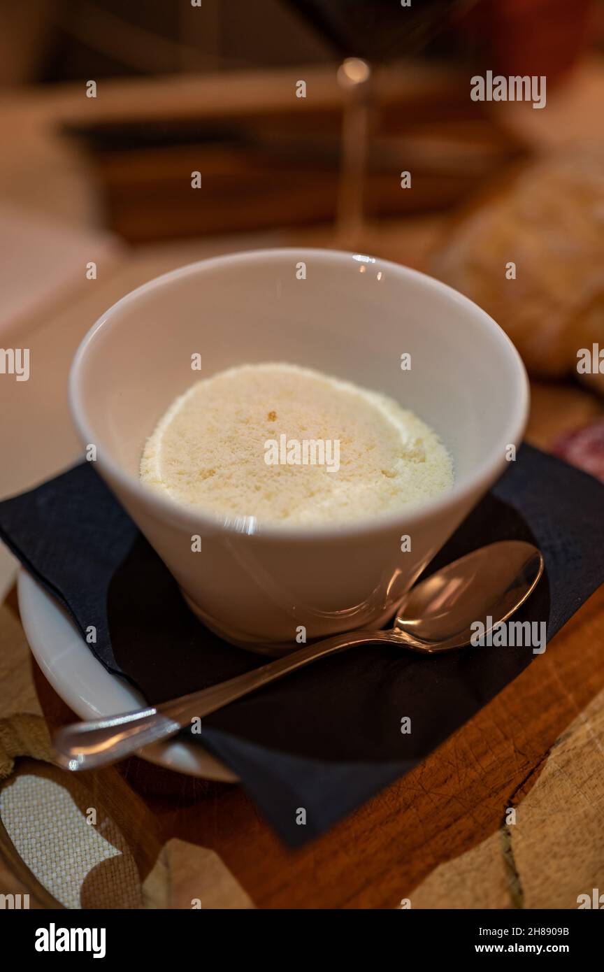 Bowl with grated parmesan Parmigiano-Reggiano hard cheese in restaurant ...
