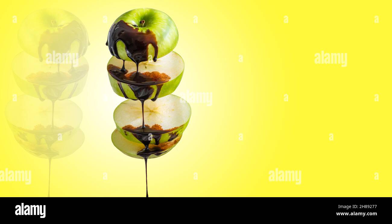 Fresh sliced green apple and melted chocolate dripping in flying food ...