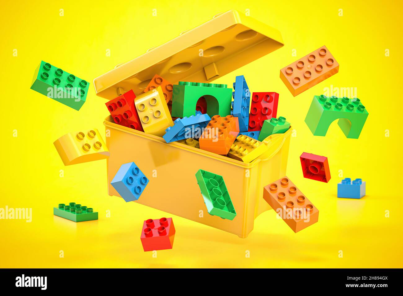 Box full of colorful toy plastic bricks and blocks on yellow background ...
