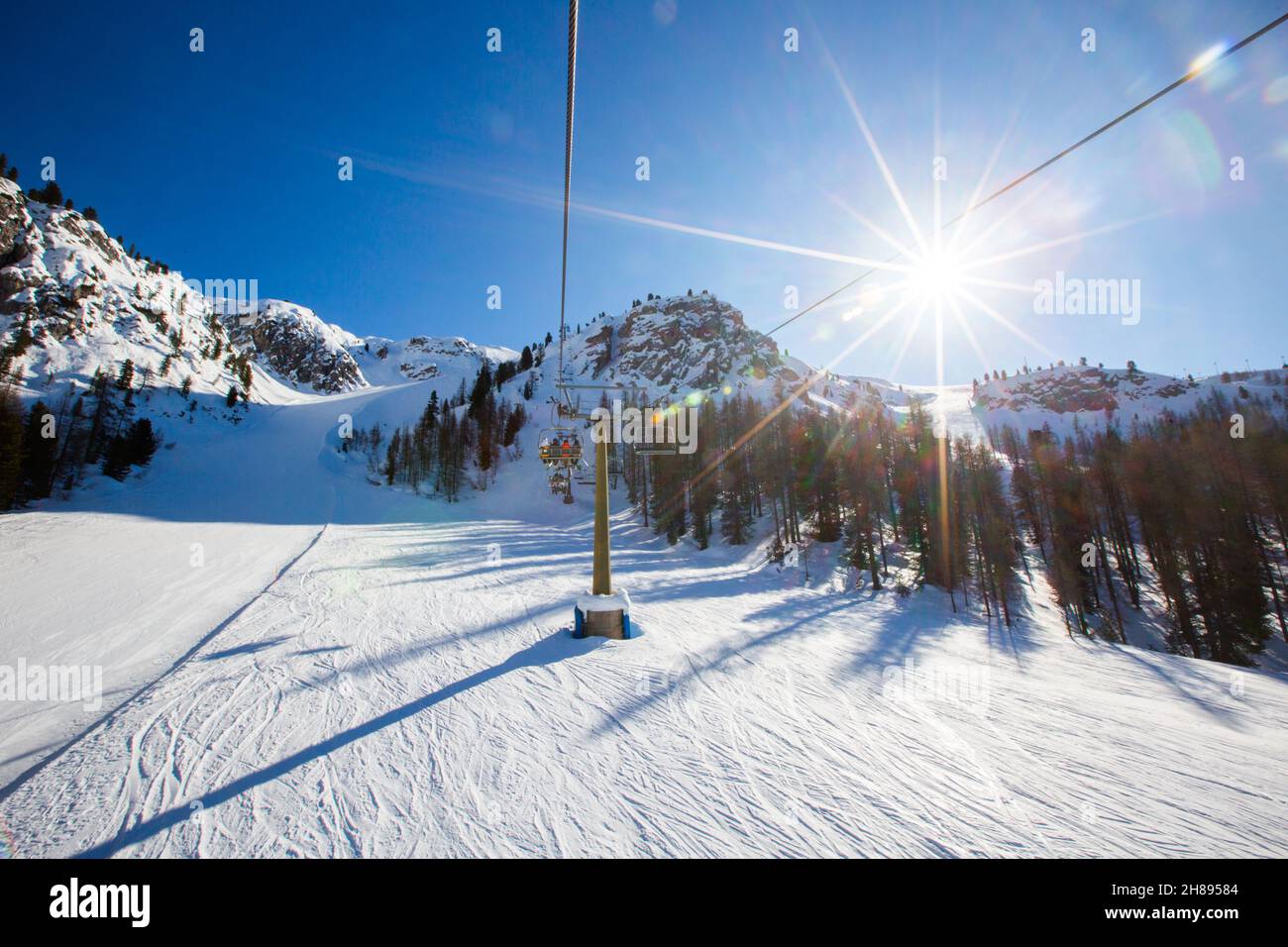 Alpine chair ski lift, slope with mountains in the background at ...
